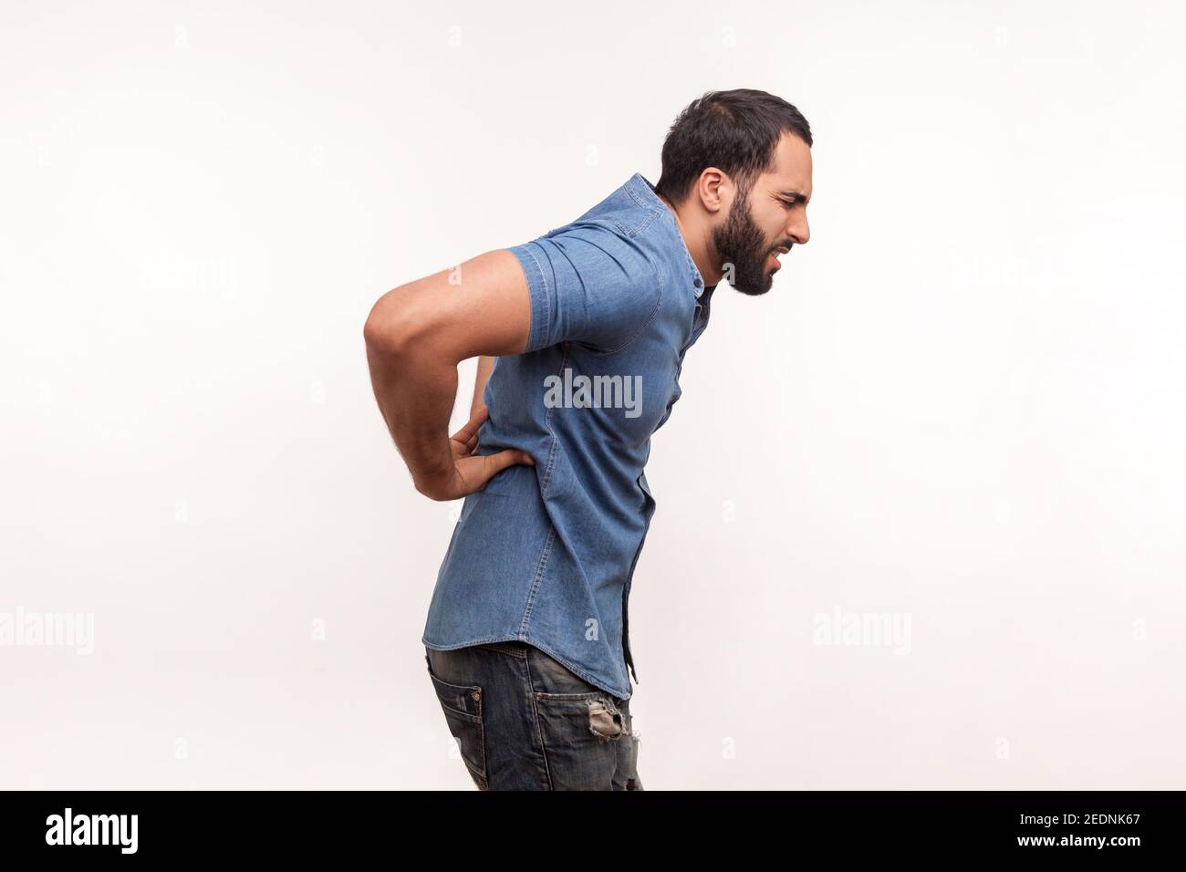 Side view exhausted unhealthy bearded man touching aching back ...