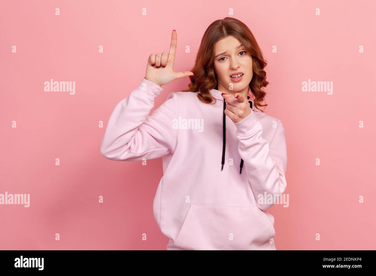 Portrait of bossy curly-haired teen expressing disrespect, showing L ...