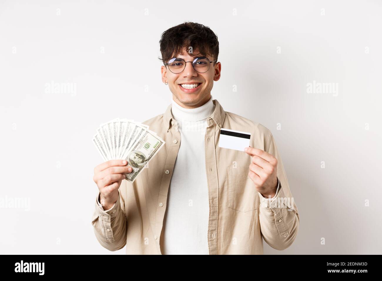 Happy person stands with money and plastic credit card. Young man ...