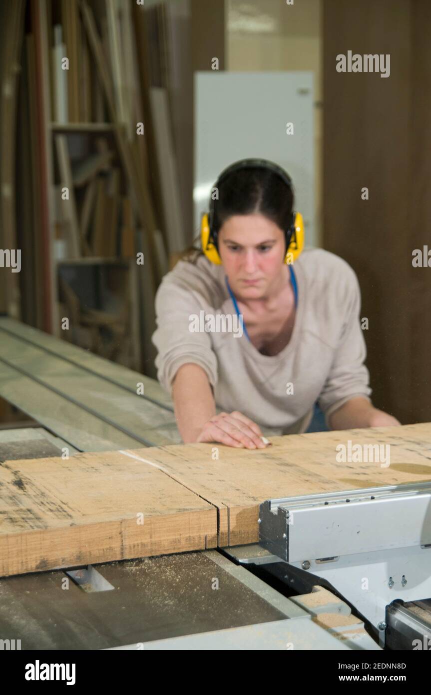 Female carpenter uses a power saw to cut oak wood Stock Photo - Alamy
