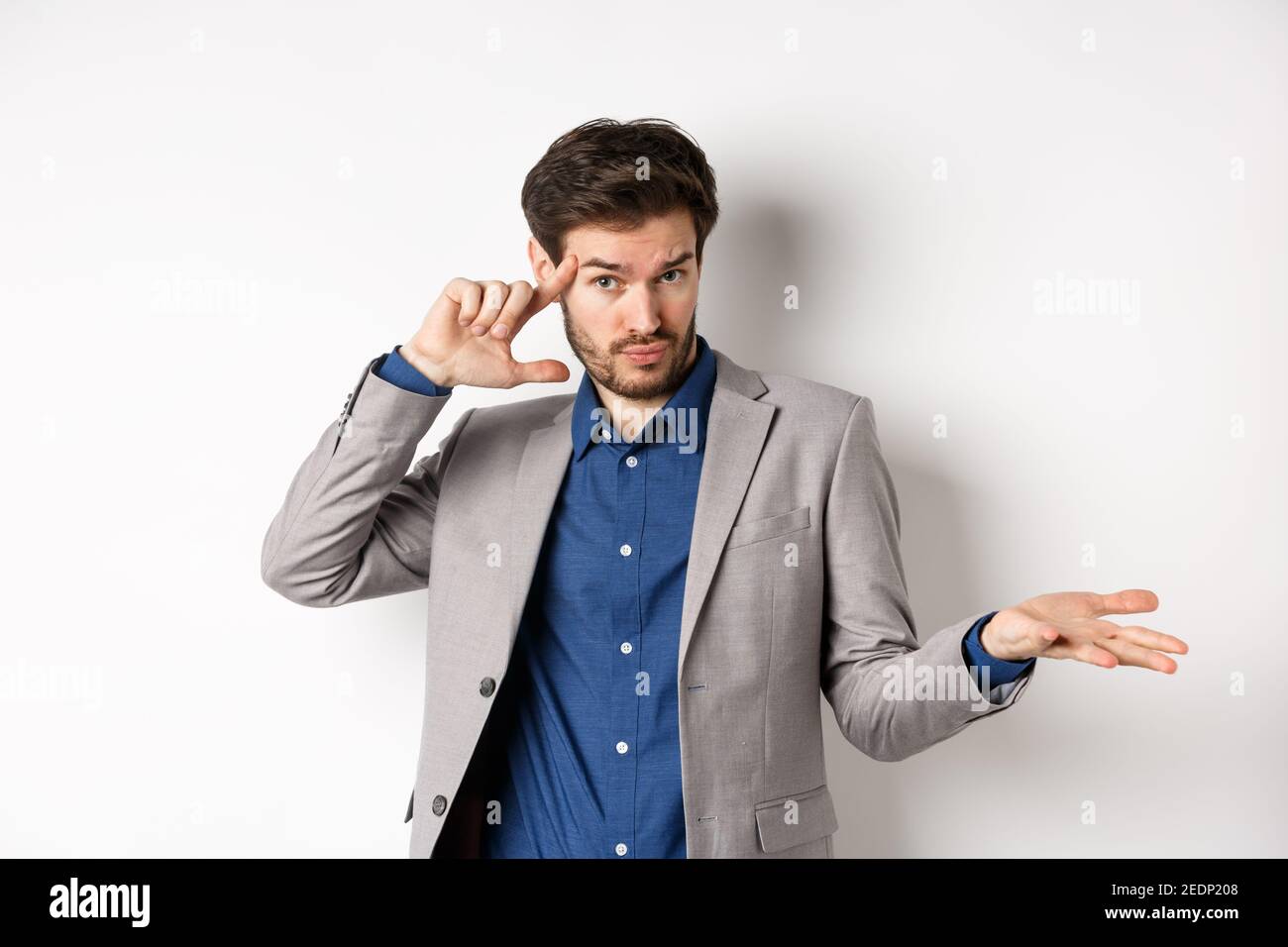 Are you crazy. Young man in suit pointing finger at head to scold ...