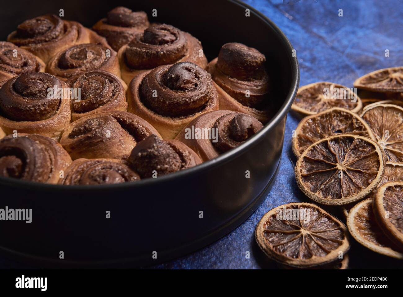High angle shot of fresh cinnamon roll buns and dried oranges Stock ...