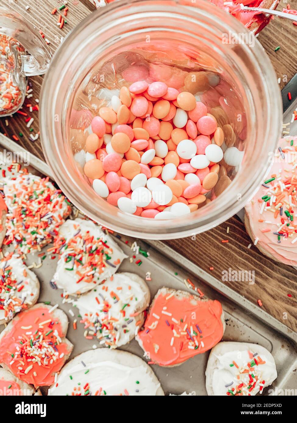 Vertical shot of colorful pearl candies in a jar and freshly baked ...