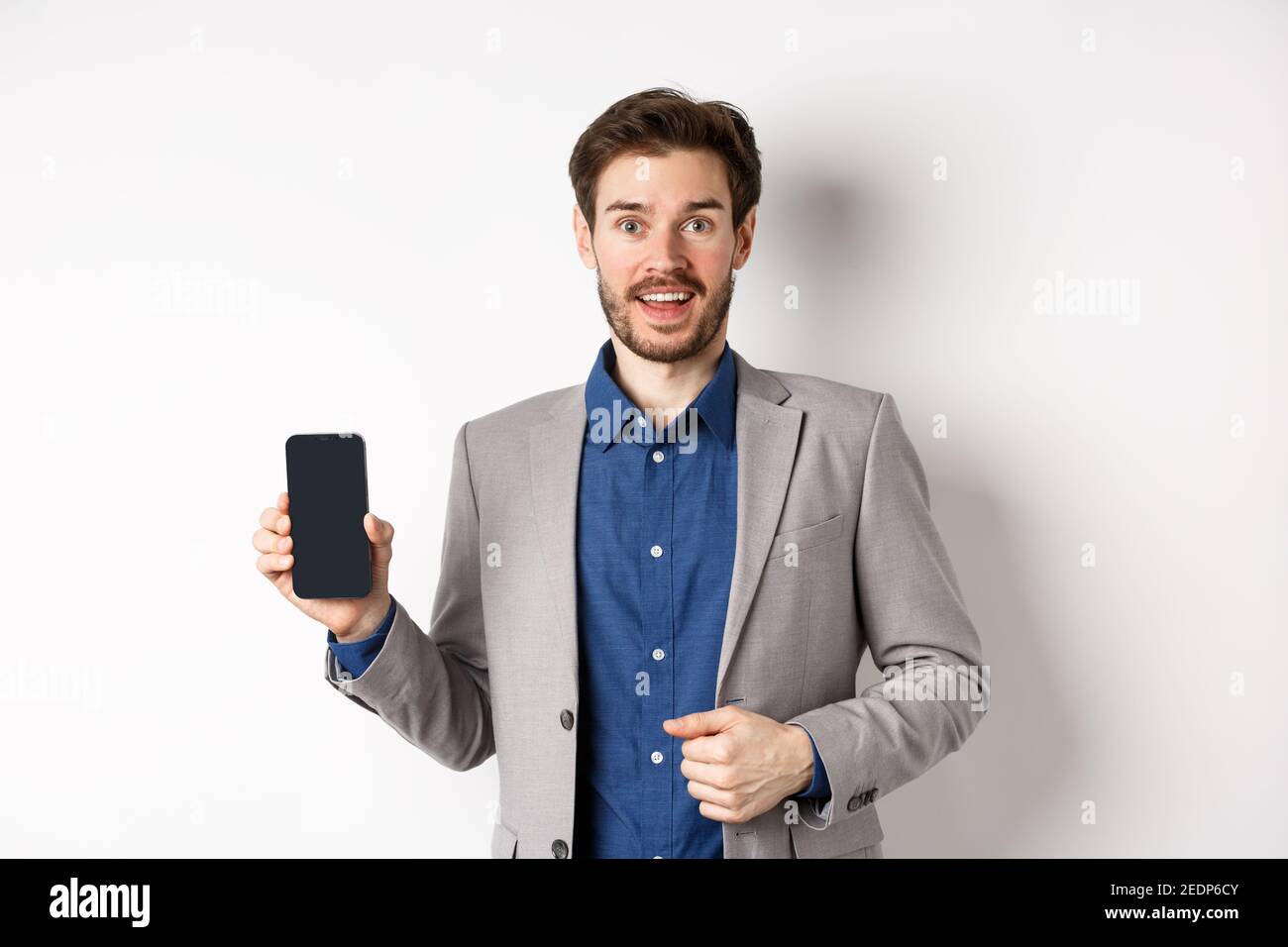 Excited businessman ceo in suit showing empty phone screen and smiling ...