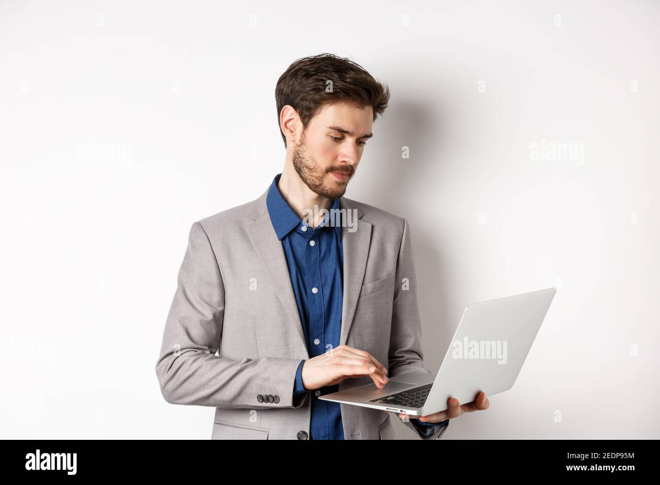 Handsome male entrepreneur working on laptop, looking serious at screen ...