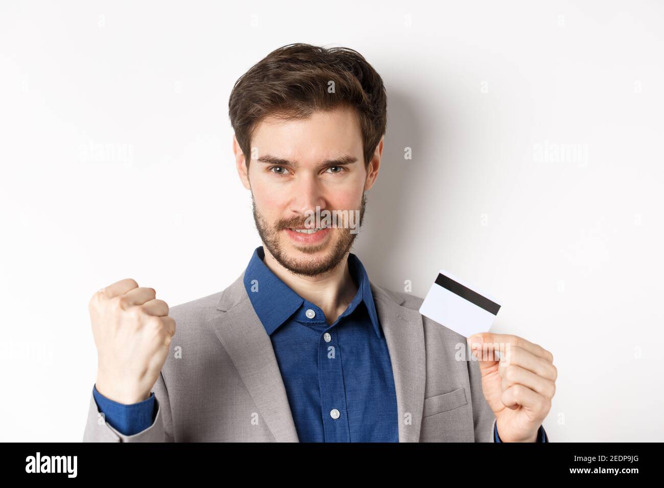 Shopping. Cheerful handsome businessman showing plastic credit card and ...