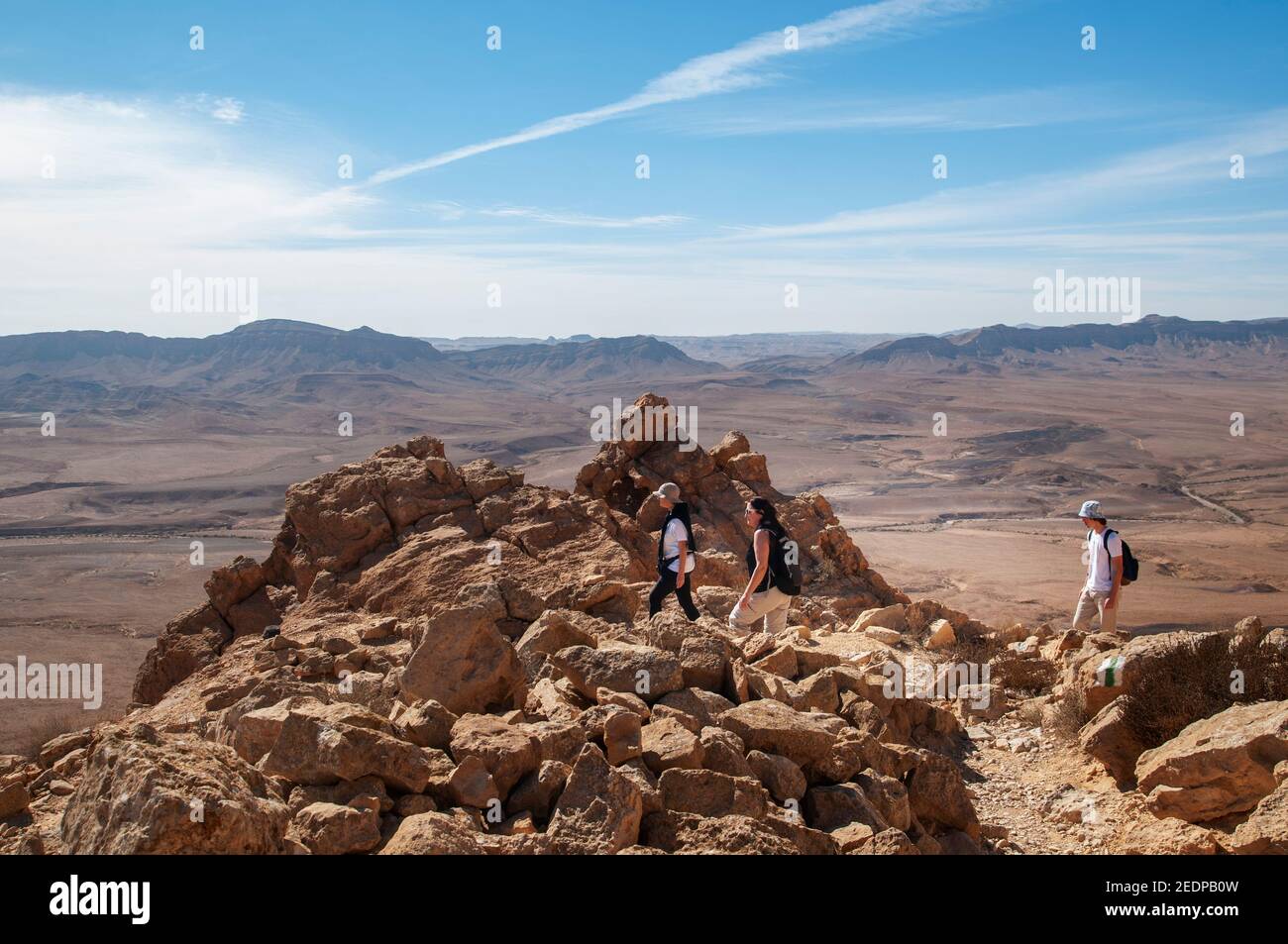 A group of hikers hiking in Makhtesh Ramon a geological feature of ...