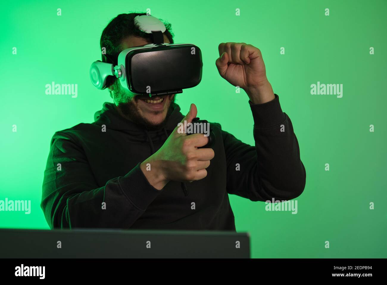 Gamer wearing virtual reality goggles, smiling and playing video games ...