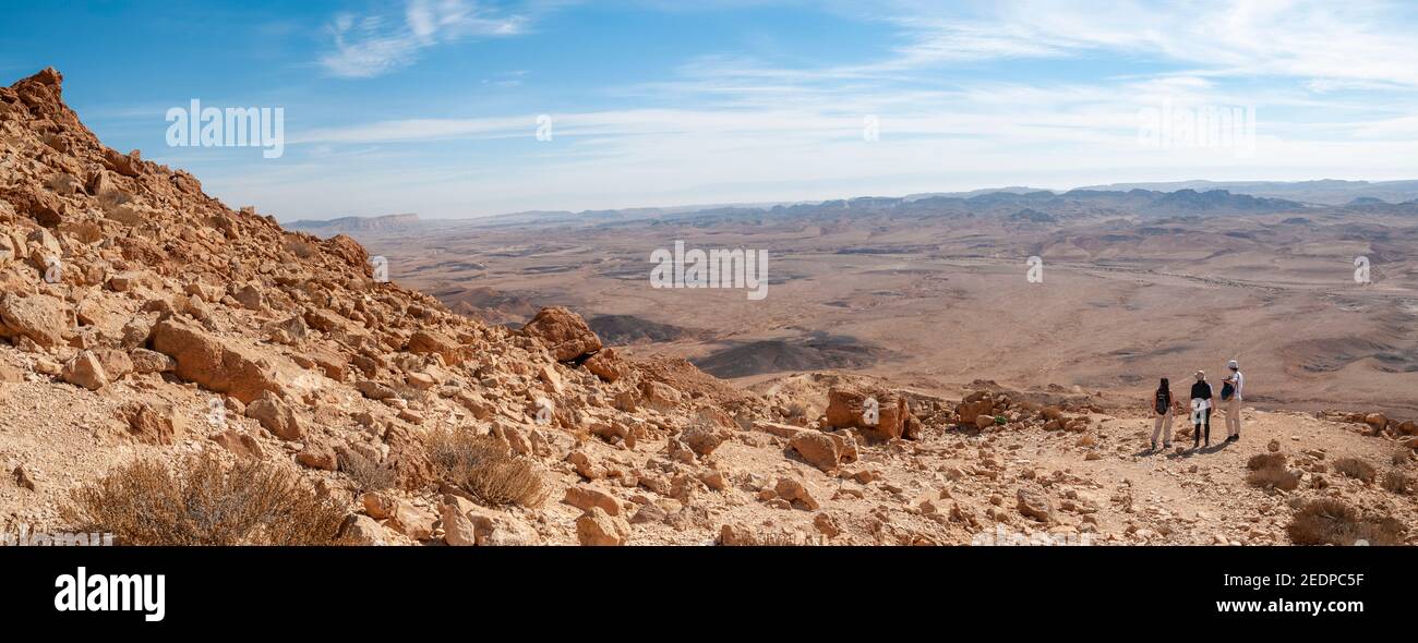 A group of hikers hiking in Makhtesh Ramon a geological feature of ...
