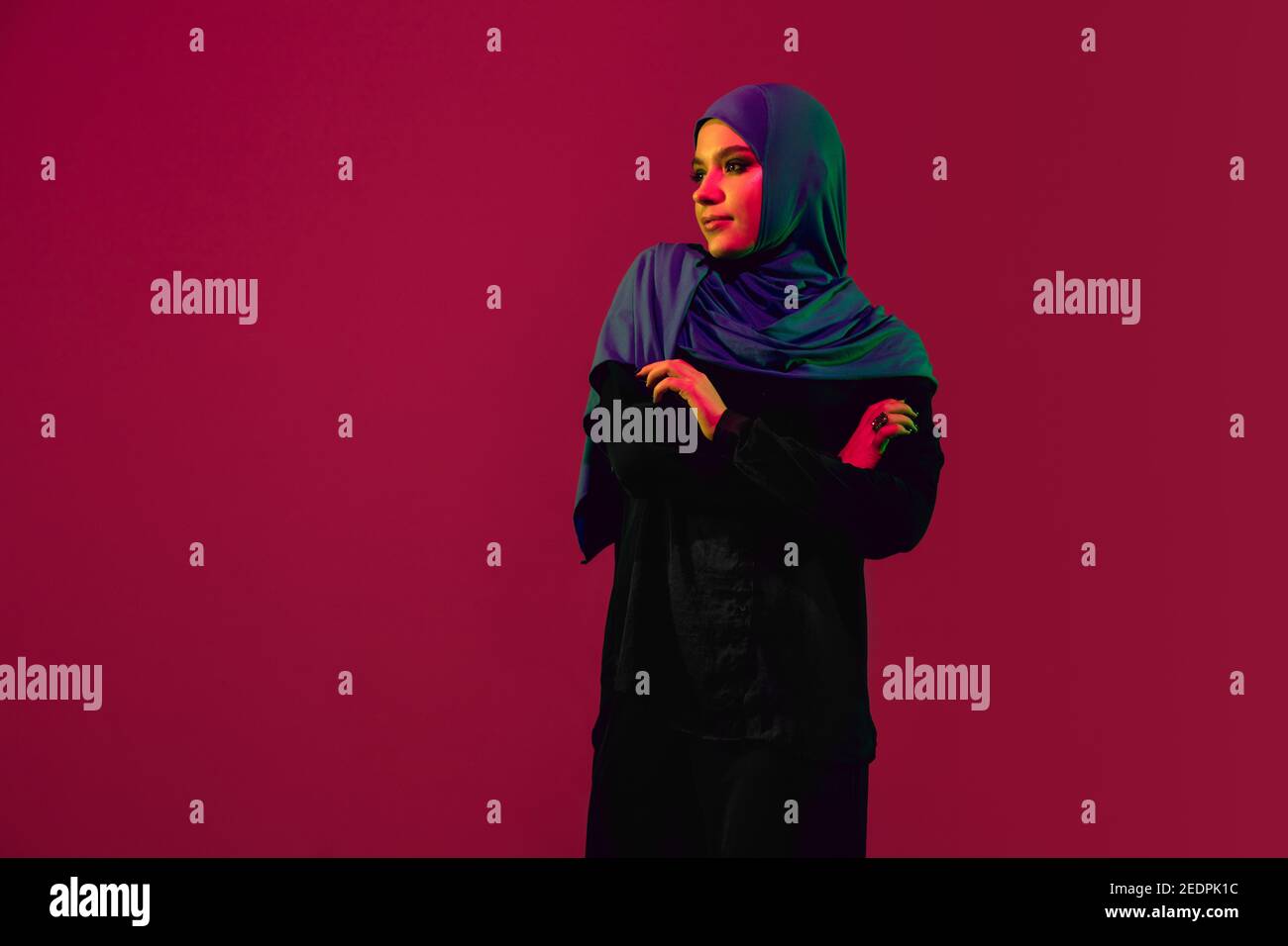 Youthful. Beautiful arab woman in stylish hijab isolated on burgundy ...