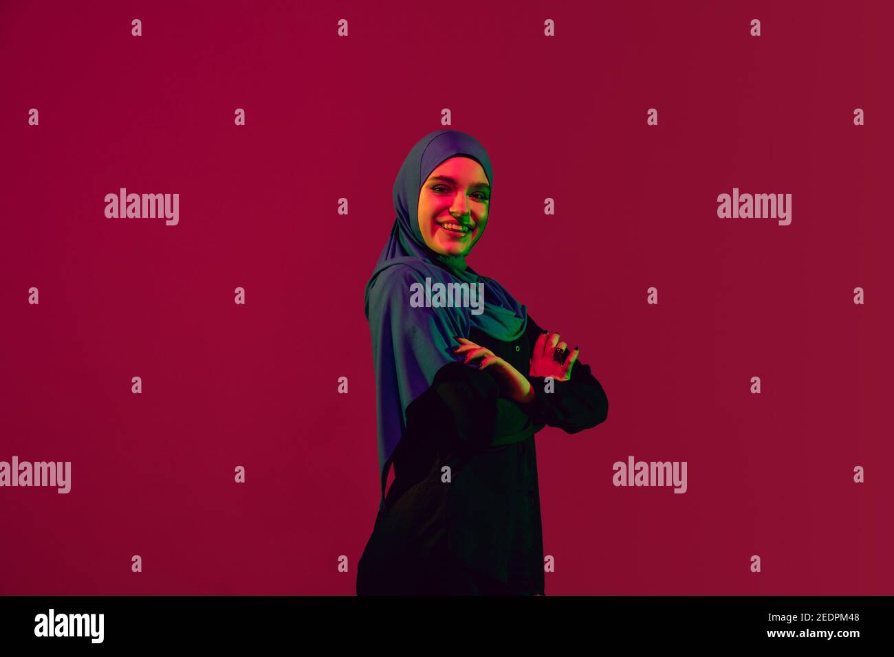 Youthful. Beautiful arab woman in stylish hijab isolated on burgundy ...