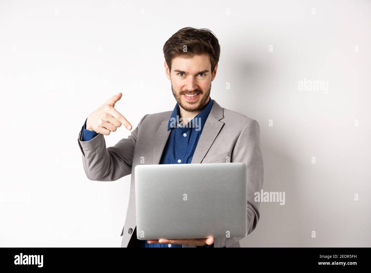 Confident young male entrepreneur working online with laptop, pointing ... Confident young male entrepreneur working online with laptop, pointing ...