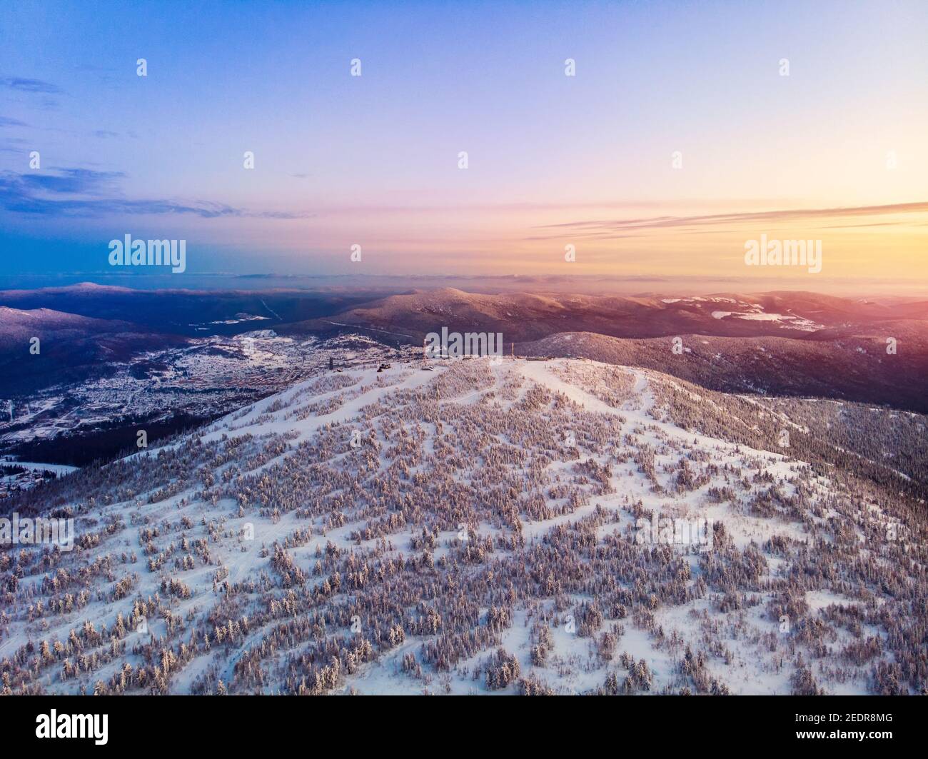Colorful winter sunset in Sheregesh ski resort mountains covered trees ...
