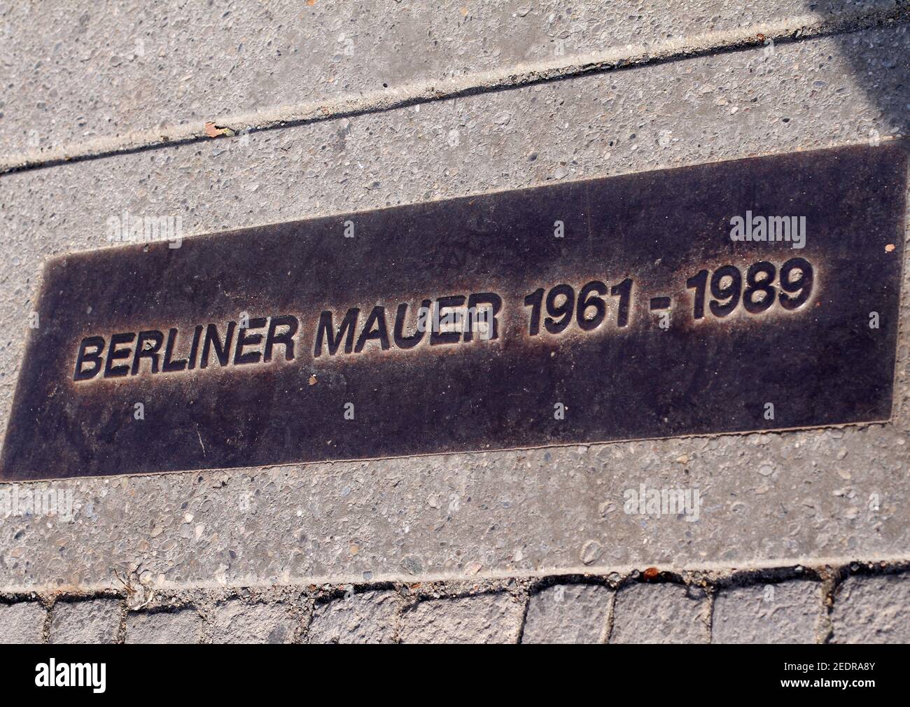 Writing Berlin Wall 1961-1989 in German on the ground in the street ...
