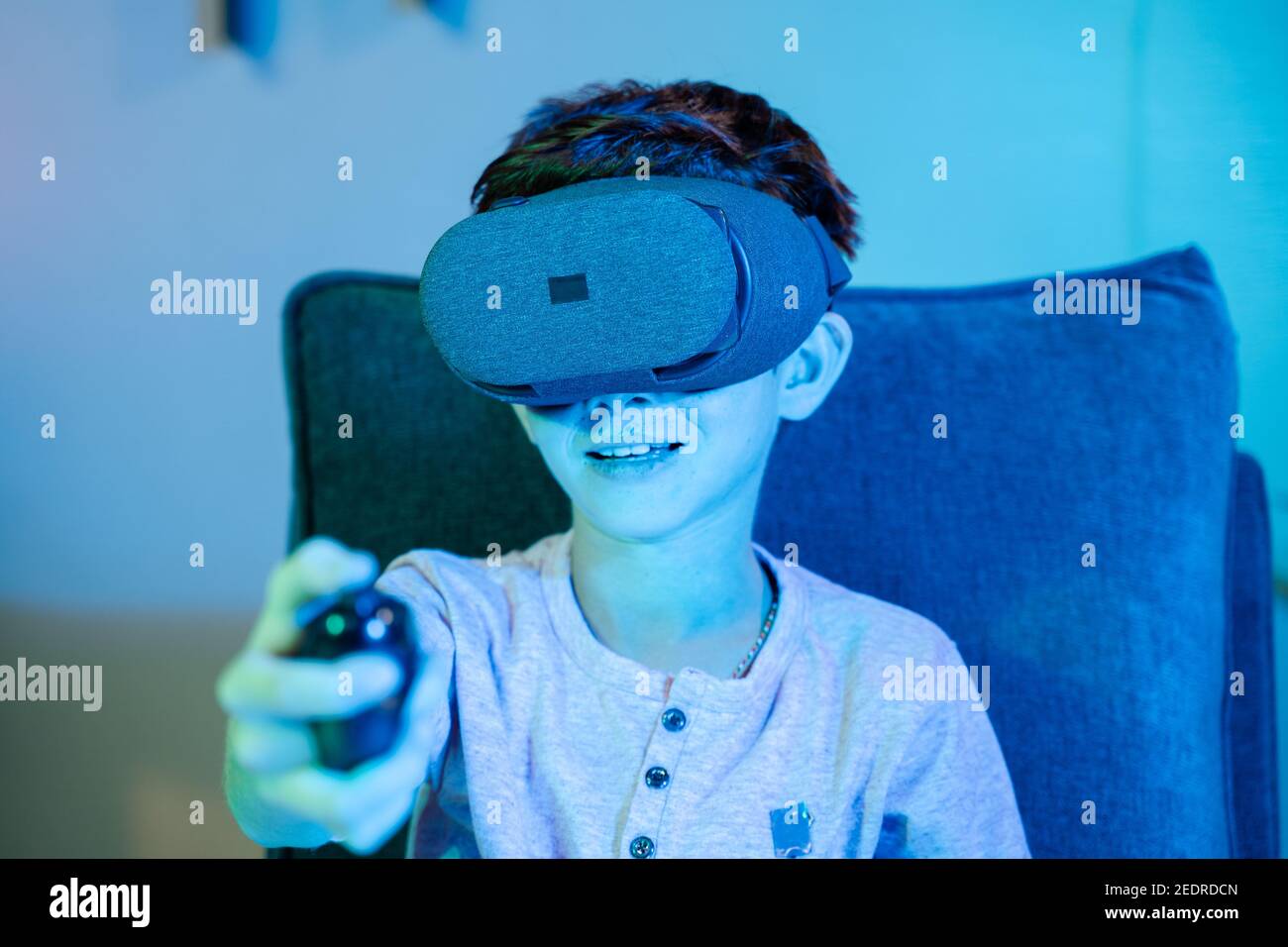Young kid playing game by wearing vr or virtual reality headset and ...