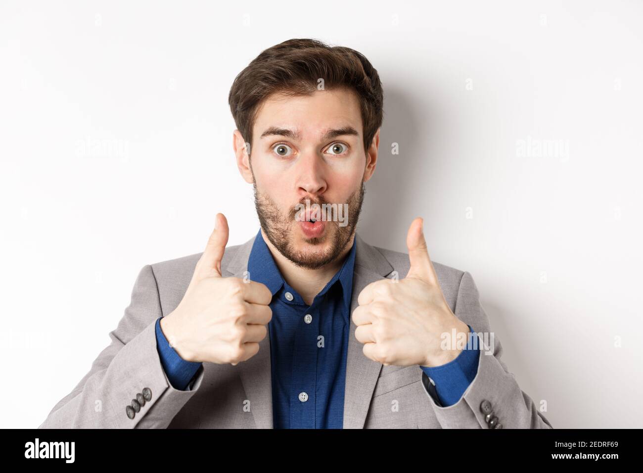 Close up portrait of excited guy in suit say wow, showing thumbs up ...