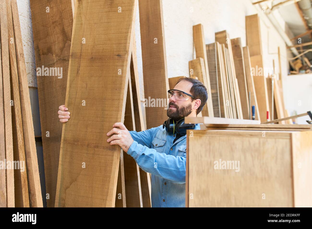 Craftsman as a carpenter or carpenter with a solid wood board in the ...