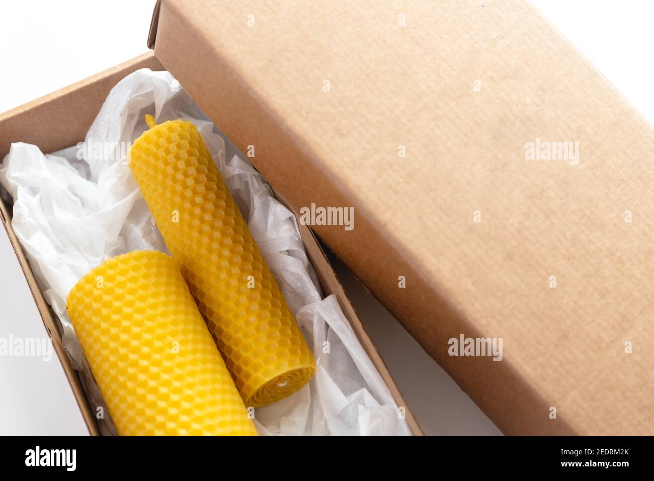Yellow candles made of bees wax in craft packaging for gift on white ...