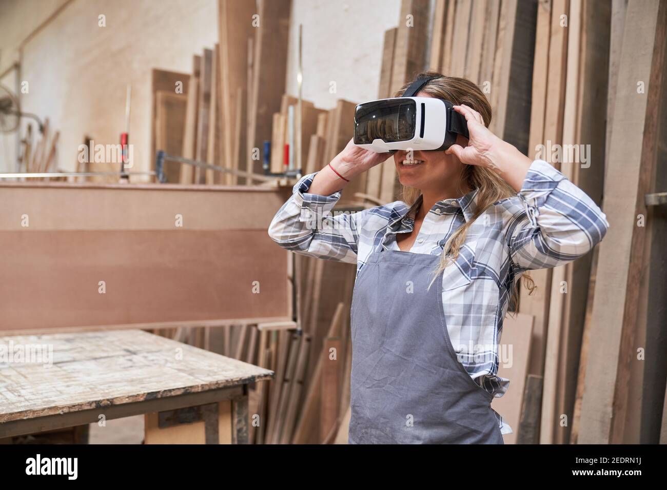 Craftsman woman looks through VR glasses to simulate the workshop of ...