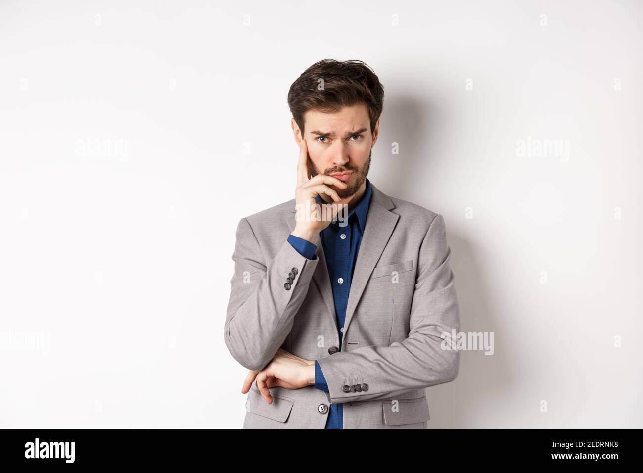 Troubled frowning business man in suit looking at camera pensive ...