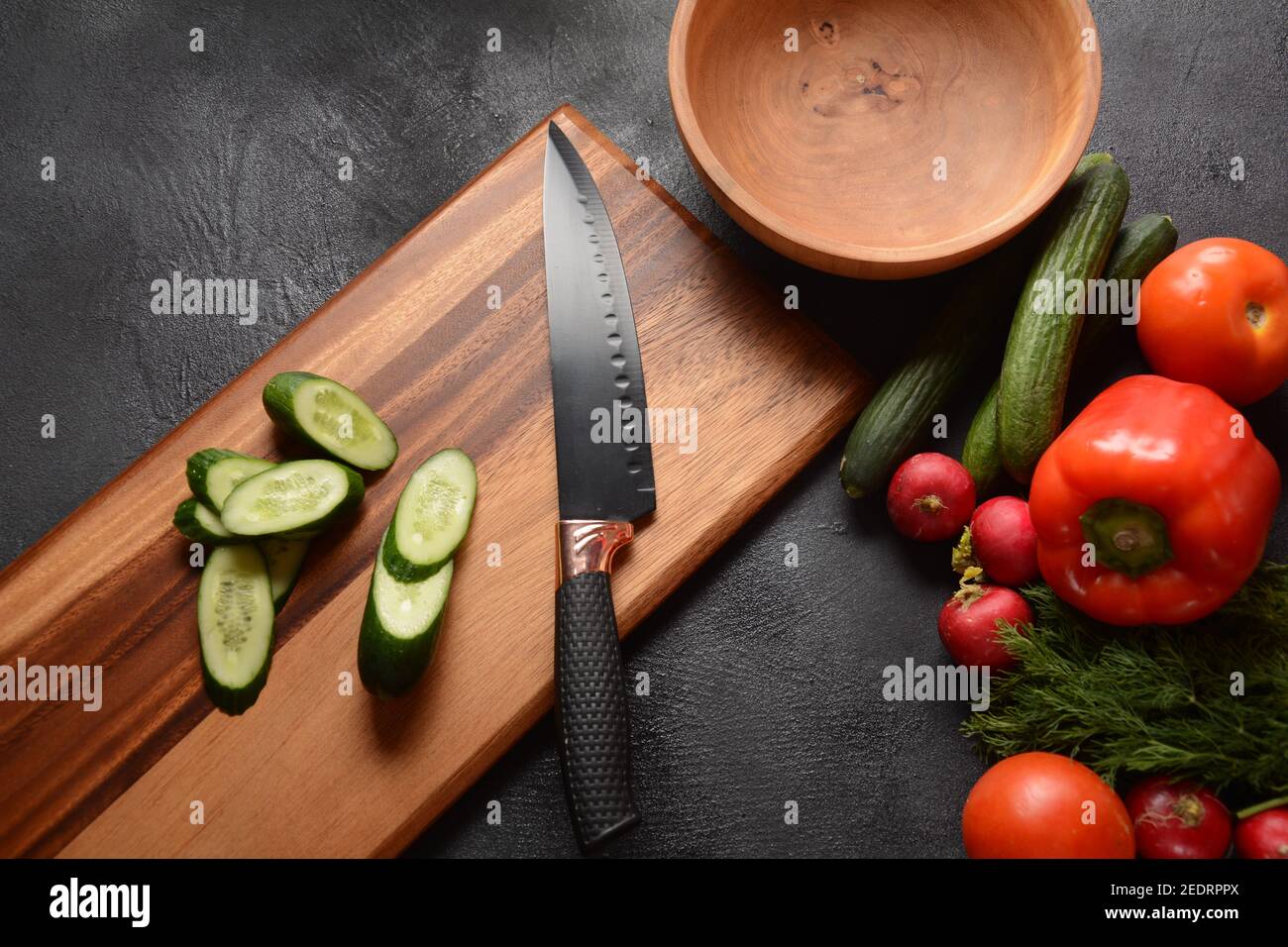 Cutting vegetables on a kitchen board. Preparing or cooking salad Stock ...