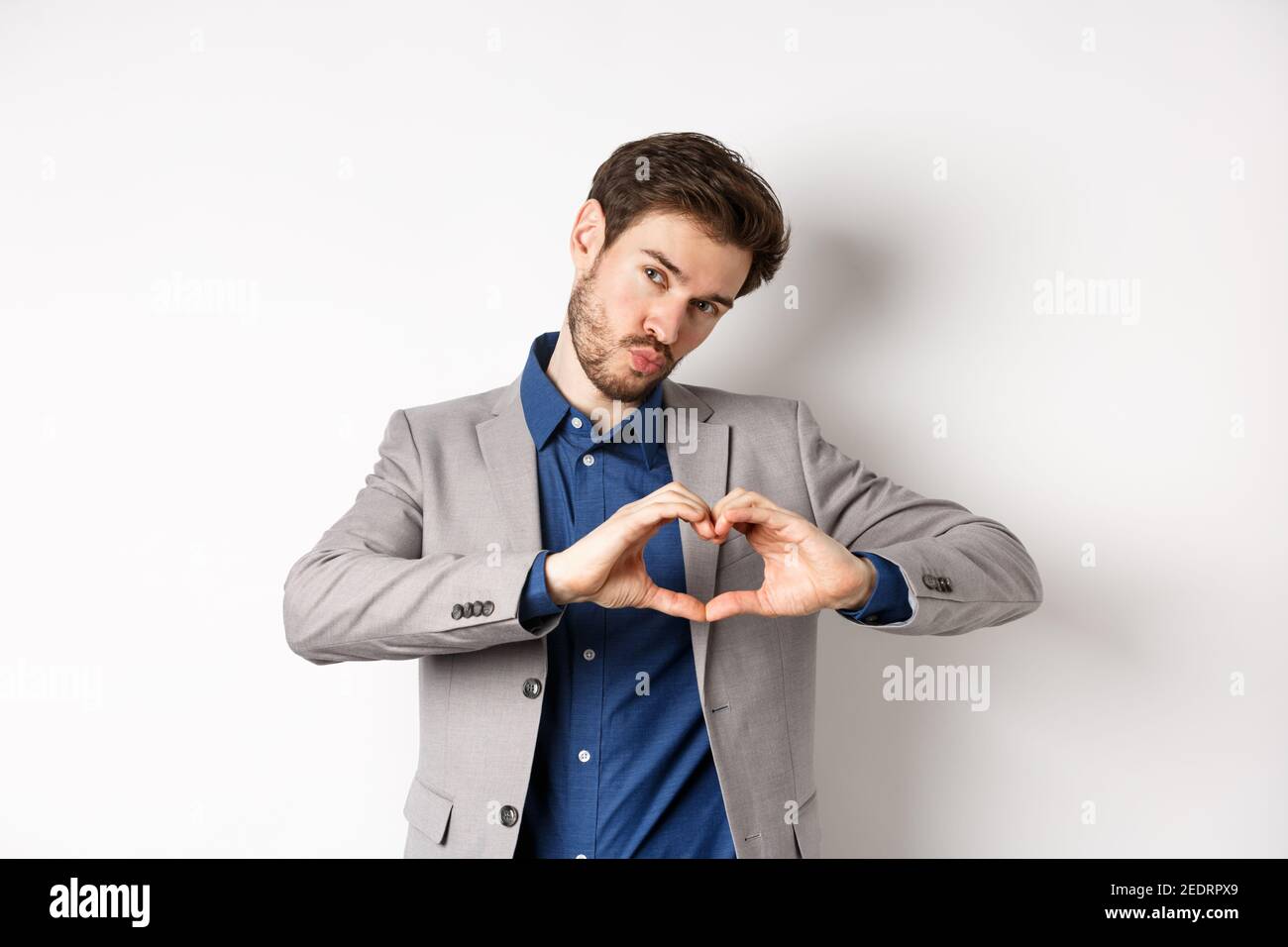 Romantic man in suit showing heart sign and pucker lips for kiss ...