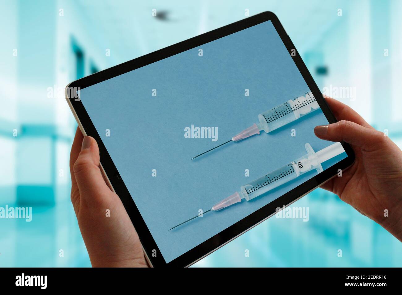 Syringes on the screen of a tablet Stock Photo - Alamy