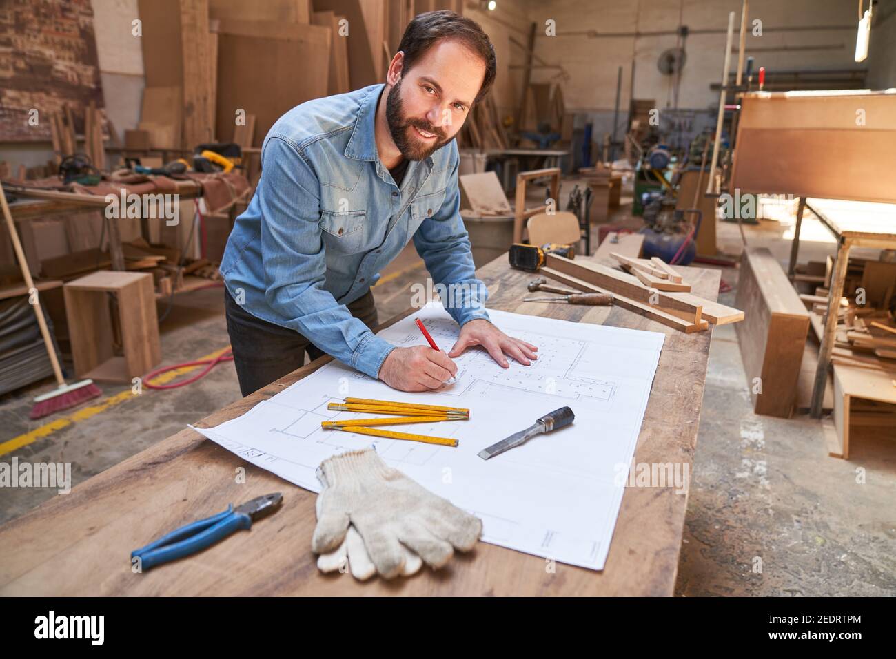 Smiling young man as an architect with architectural drawing during a ...