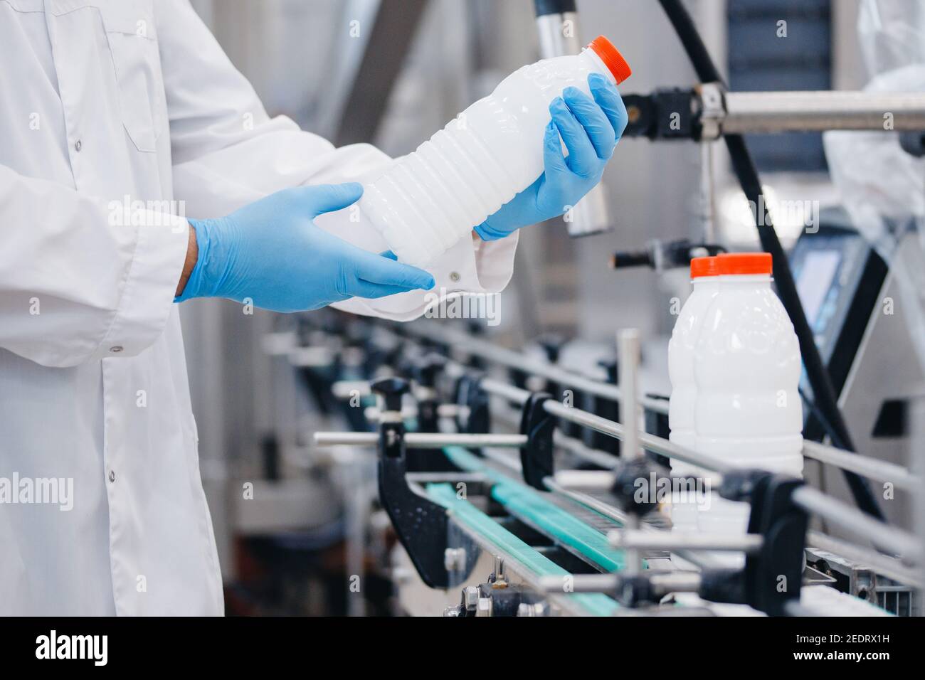 Man worker operator inspecting milk bottles production line dairy ...
