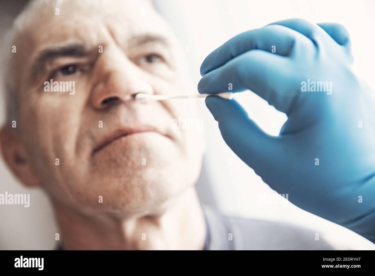 Medical worker wearing protective equipment testing senior old man for ...