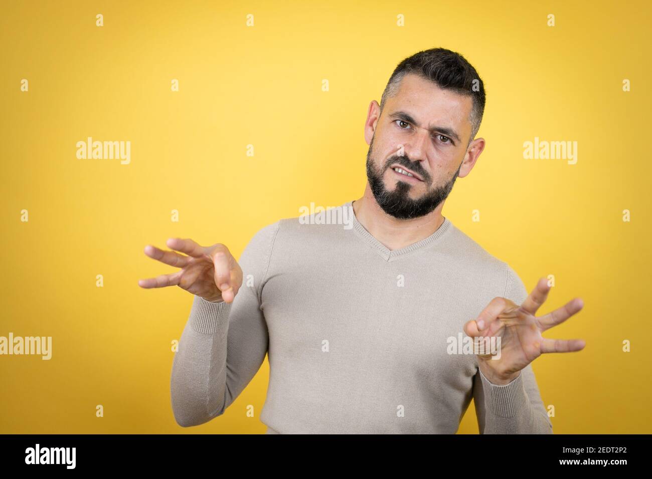 Handsome man with beard wearing sweater over yellow background ...