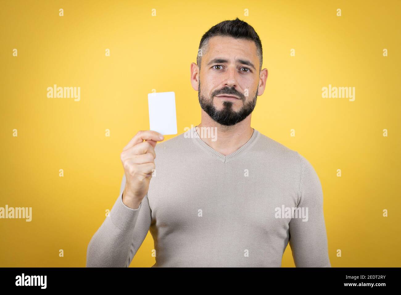Handsome man with beard wearing sweater over yellow background smiling ...