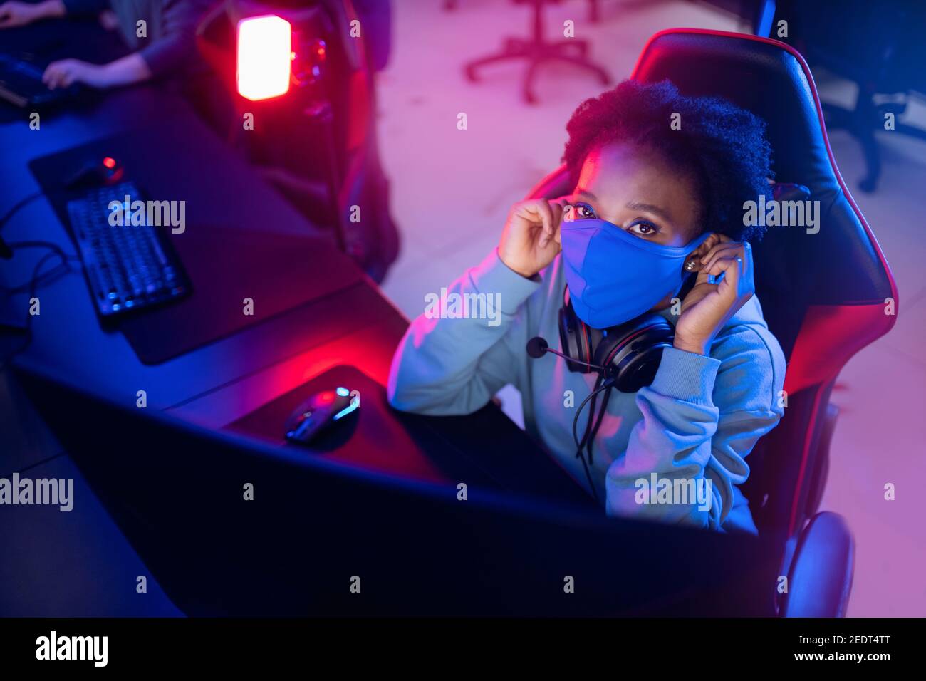 Streamer gamer African American young girl in protective mask computer ...