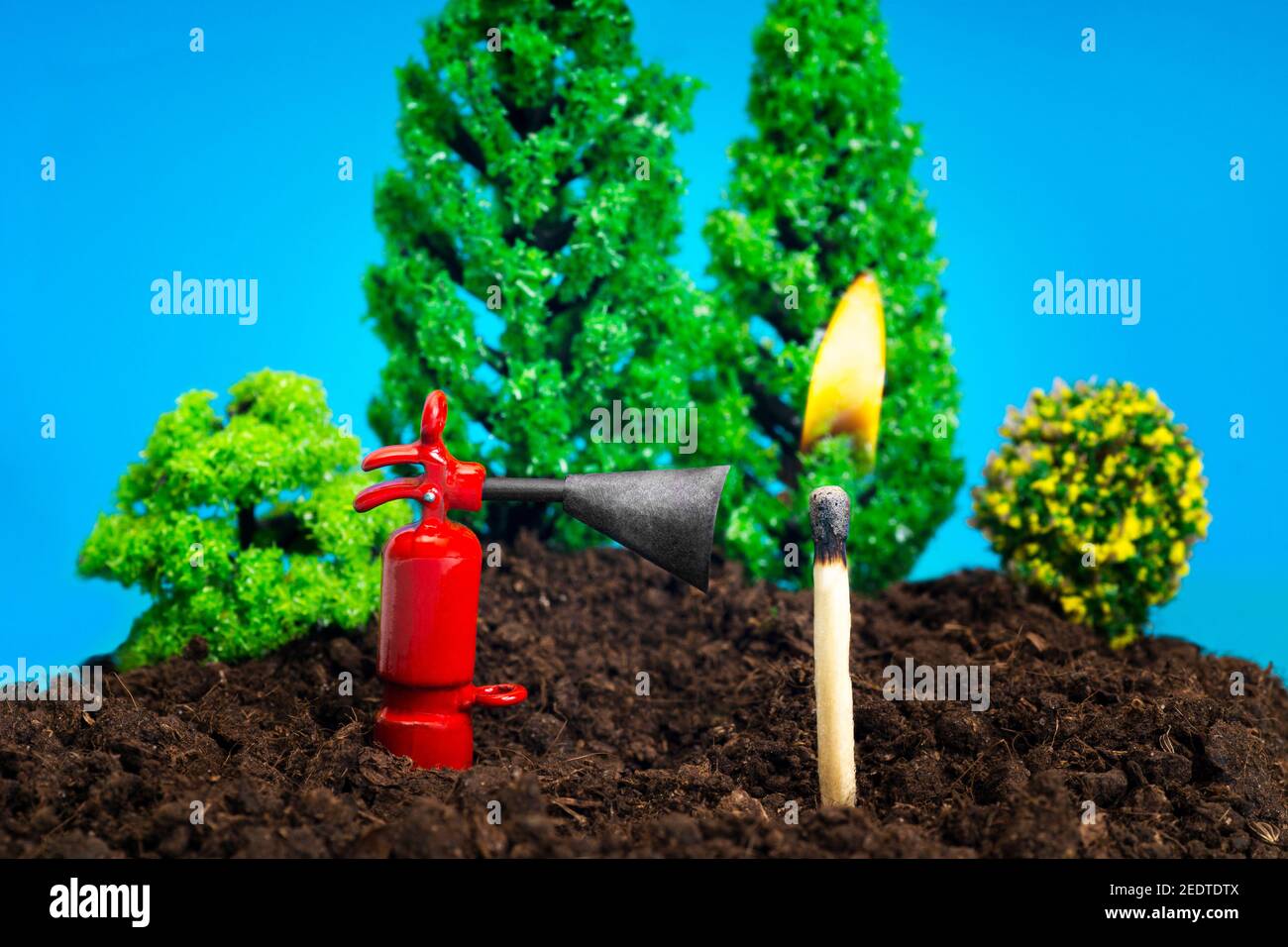 Close-up of a miniature toy forest with a tiny fire extinguisher next ...