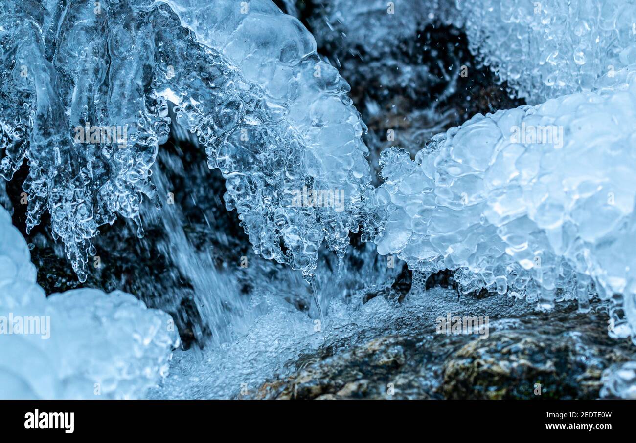 frozen water around a flowing stream Stock Photo - Alamy