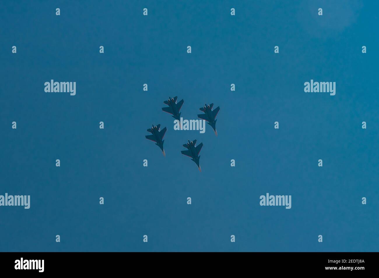 Low angle of the four powerful military fighter jets flying in the blue ...