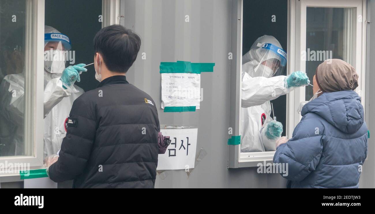 Nurses wearing personal protective equipment suits (PPE) take swab ...
