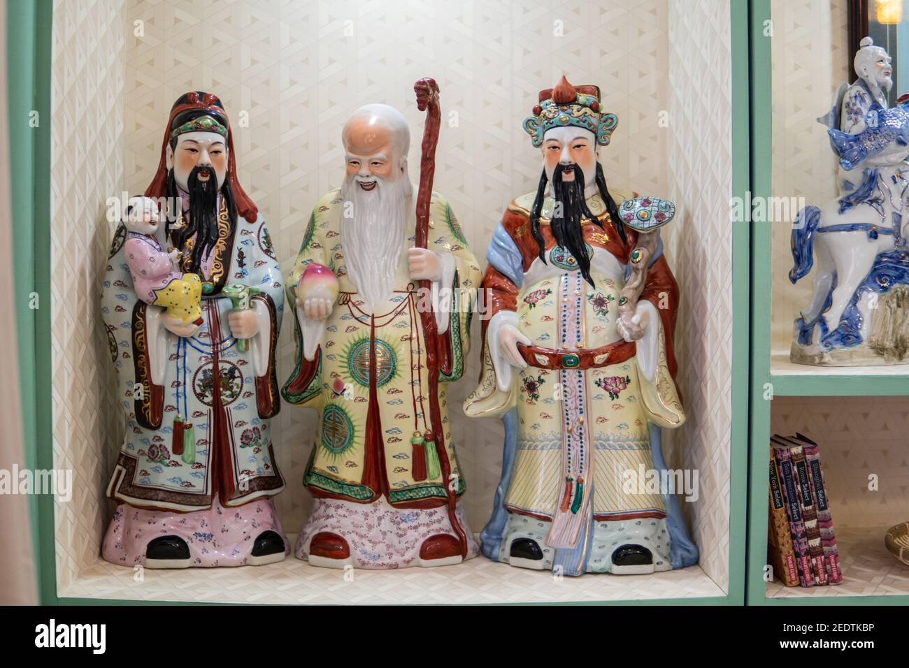 Closeup of the traditional ceramic statues of the Chinese gods of luck ...