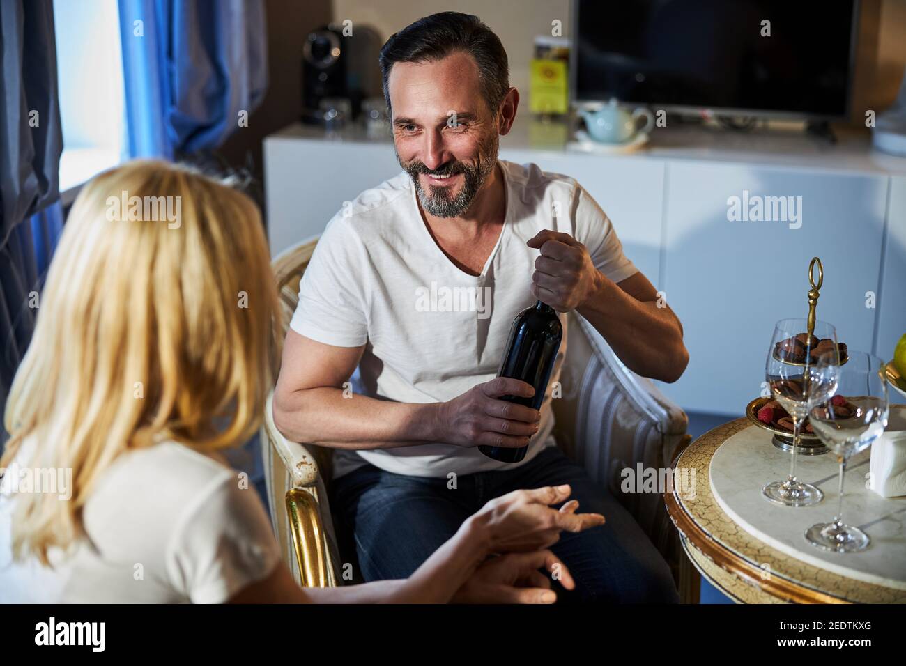 Cheerful gentleman and blonde lady having dinner at home Stock Photo ...