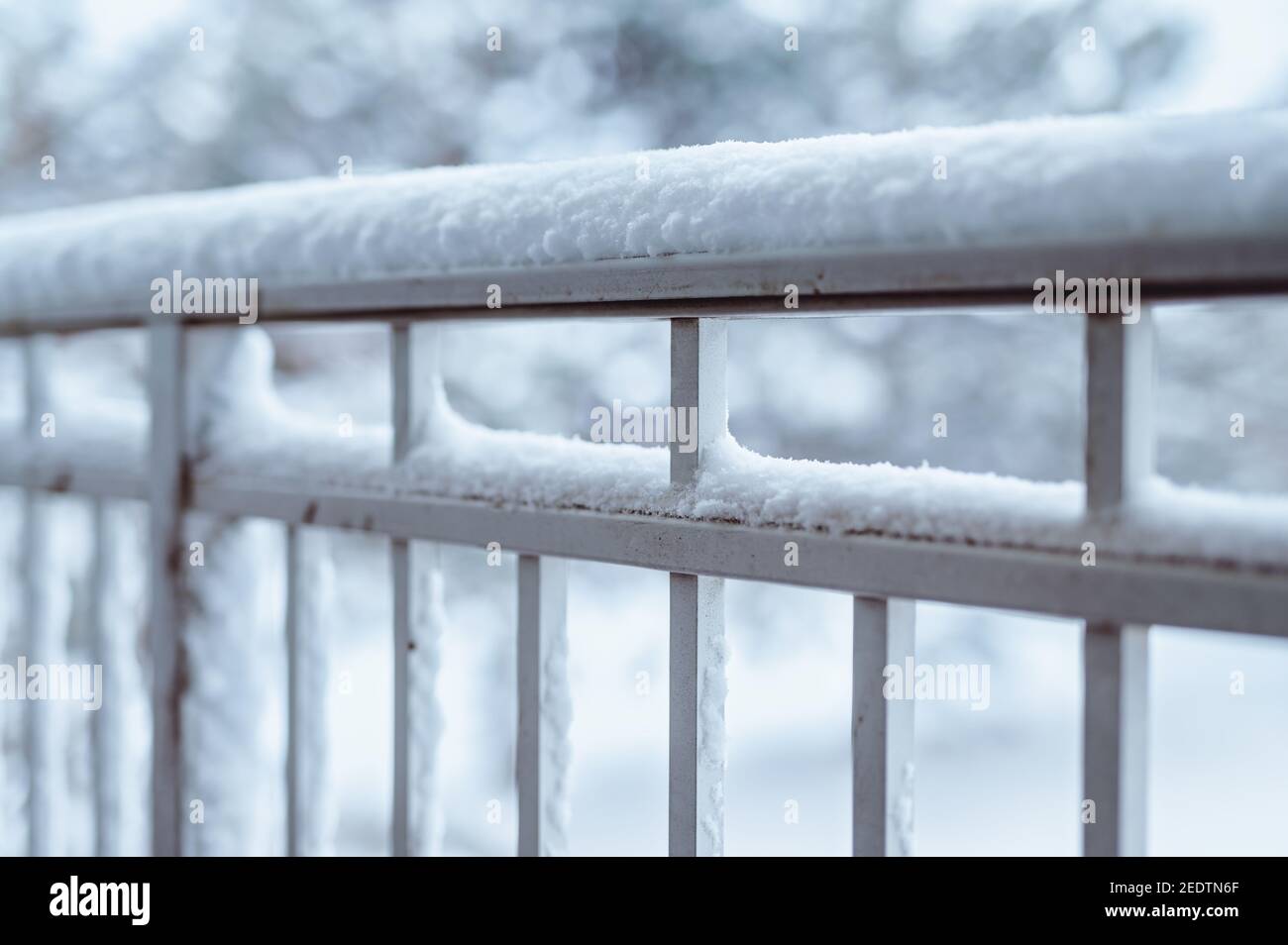 Selective focus shot of a metal railing covered in white snow during ...