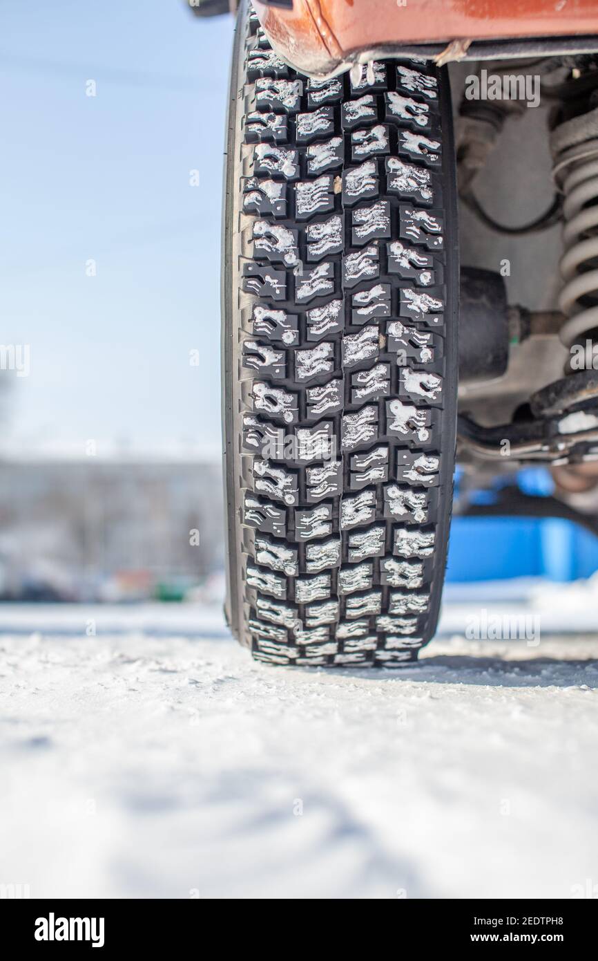 Car wheel on snow in winter close-up. The suspension and chassis of the ...