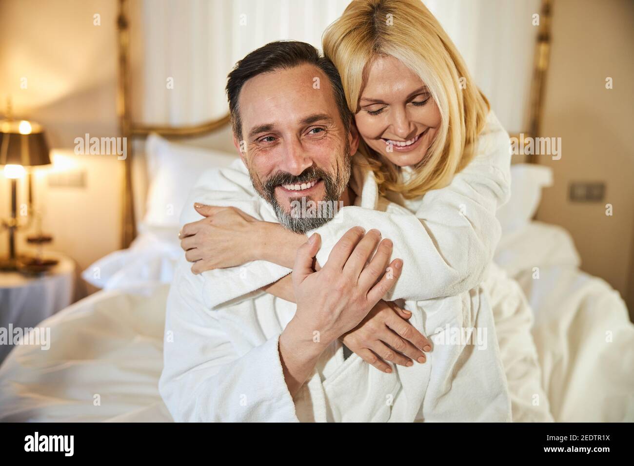 Bearded gentleman receiving loving embrace from his girlfriend Stock ...