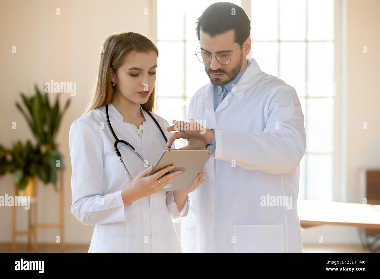 Two professional general practitioners using modern tech gadget Stock ...