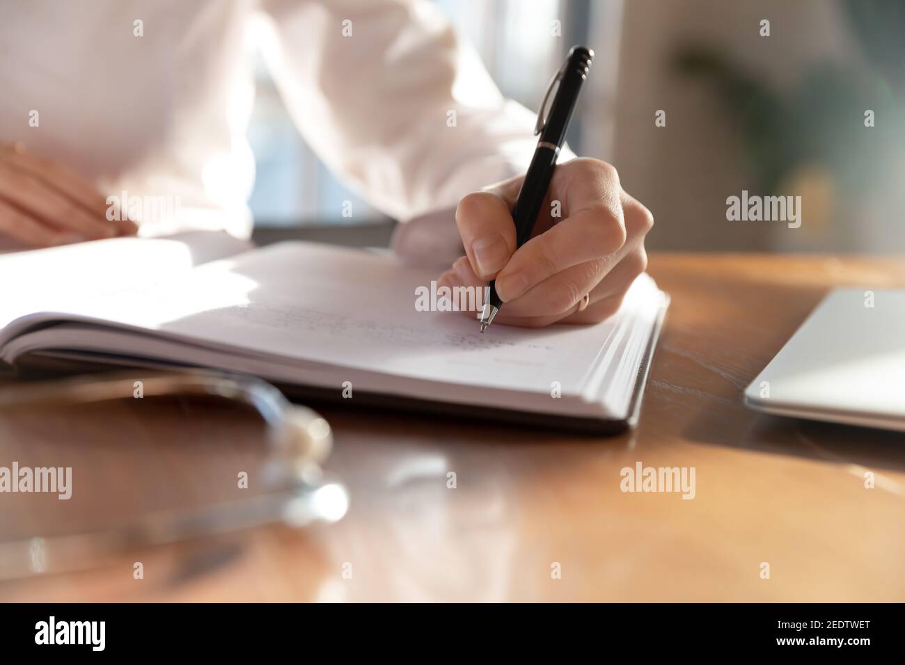 Close up young female physician therapist making notes Stock Photo - Alamy