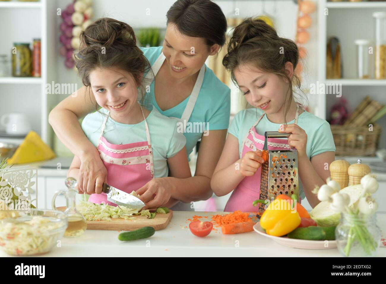Cute happy girls coocking on kitchen with mother Stock Photo - Alamy
