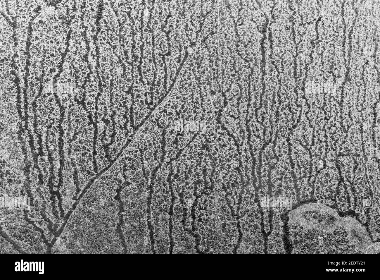 Frozen ice coated window pane with patterns left by coating crystals ...