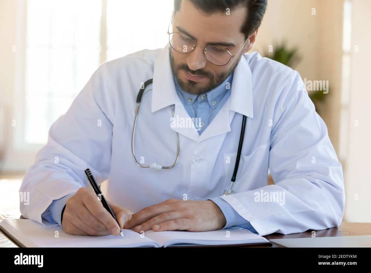 Doctor writing patient information hi-res stock photography and images ...
