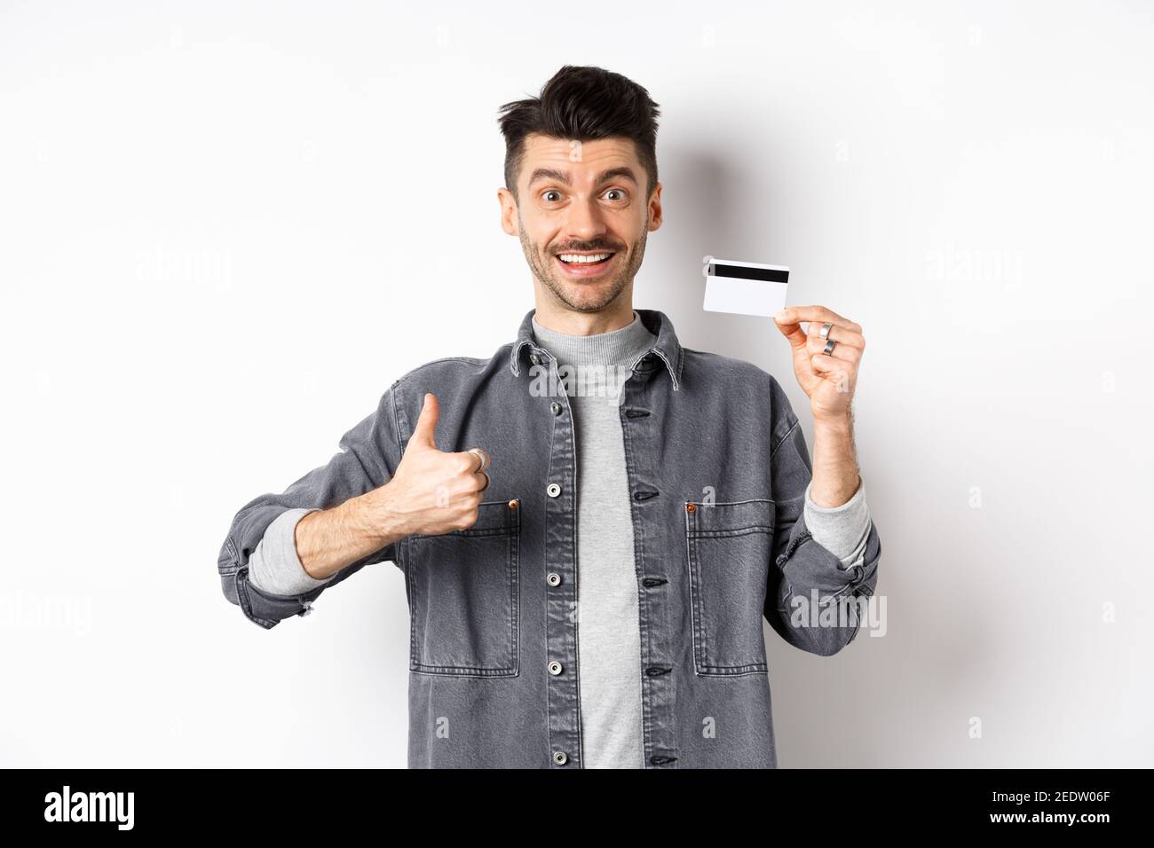 Very good. Smiling guy with plastic credit card showing thumbs up ...