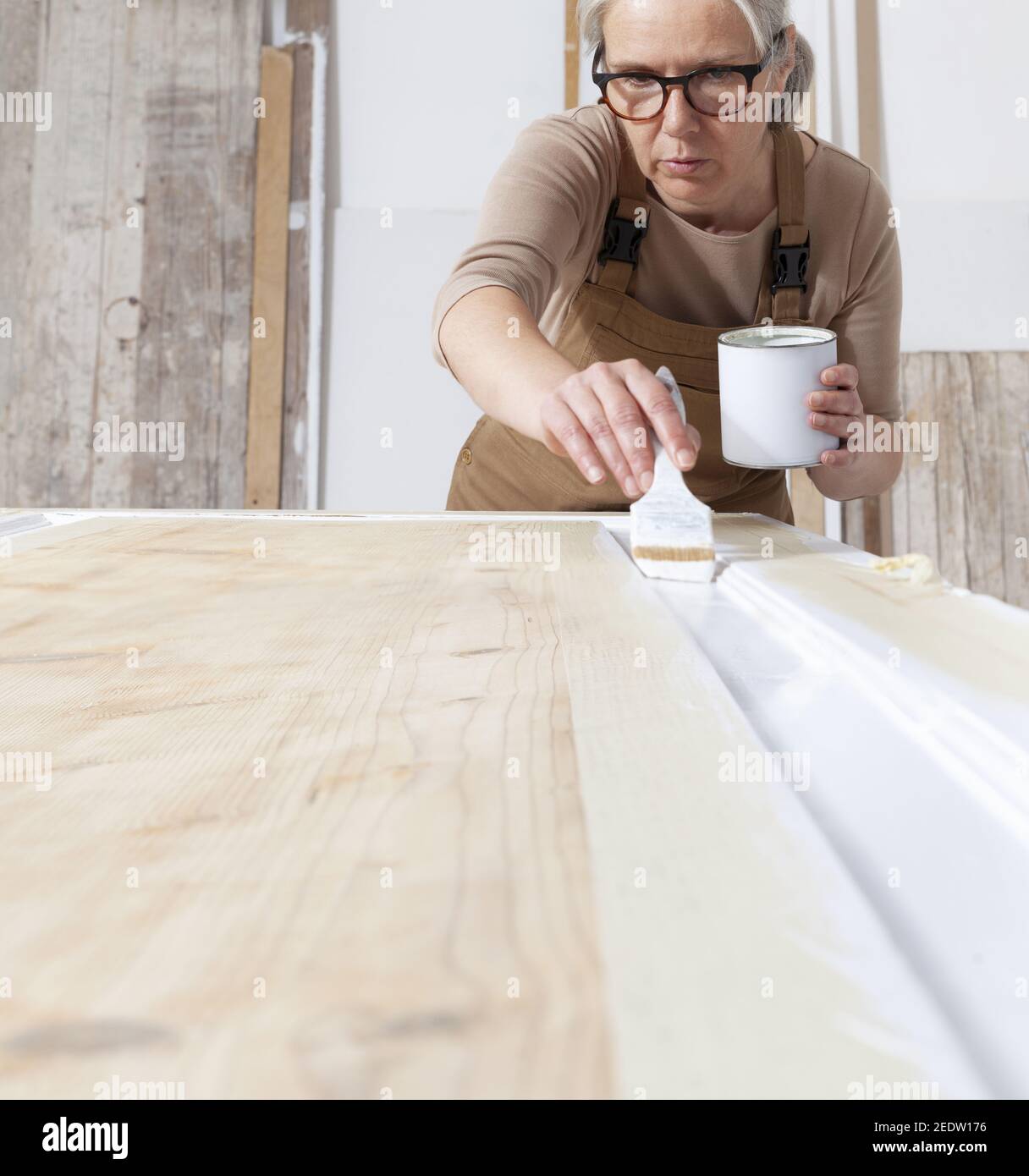 wood crafts, woman artisan carpenter painting with brush and paint jar ...