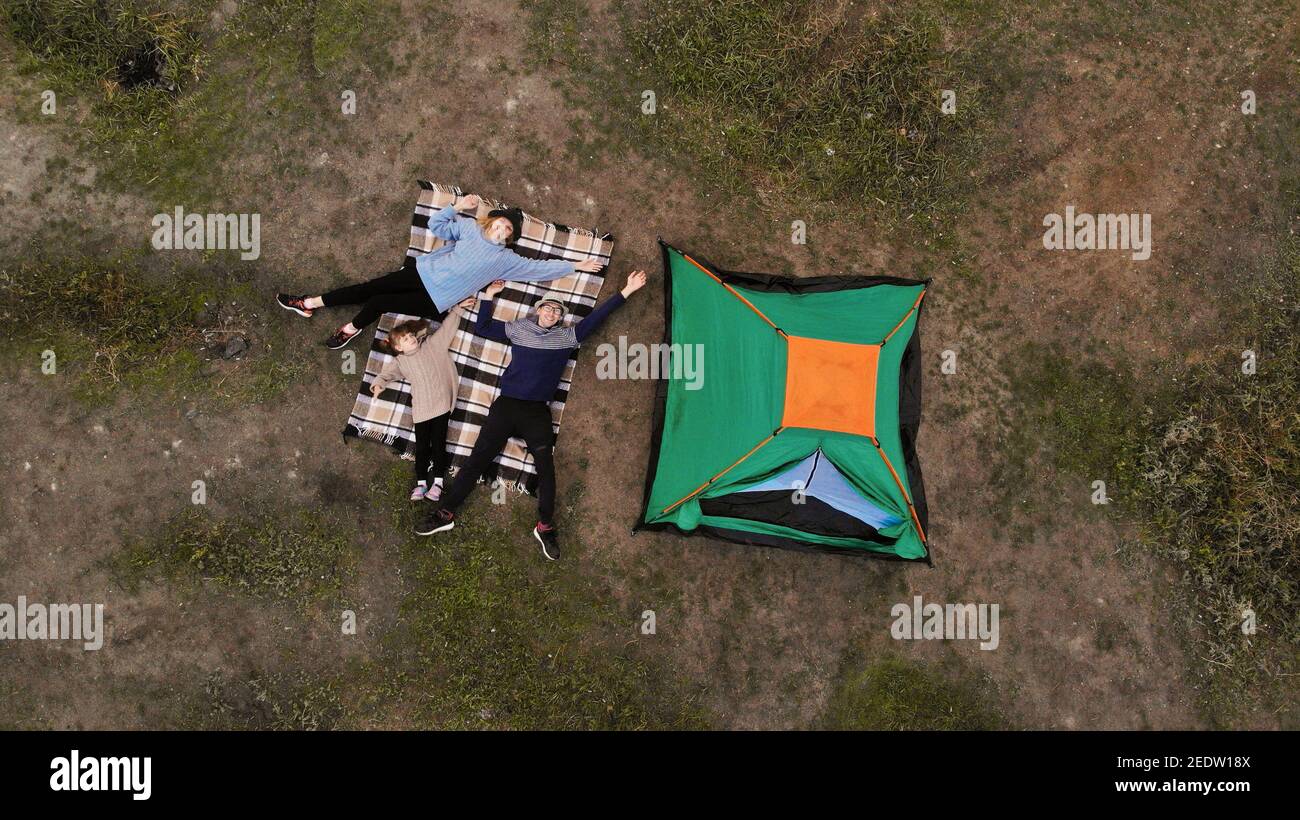 Aerial top view of family in campsite from above, parents and kid relax ...